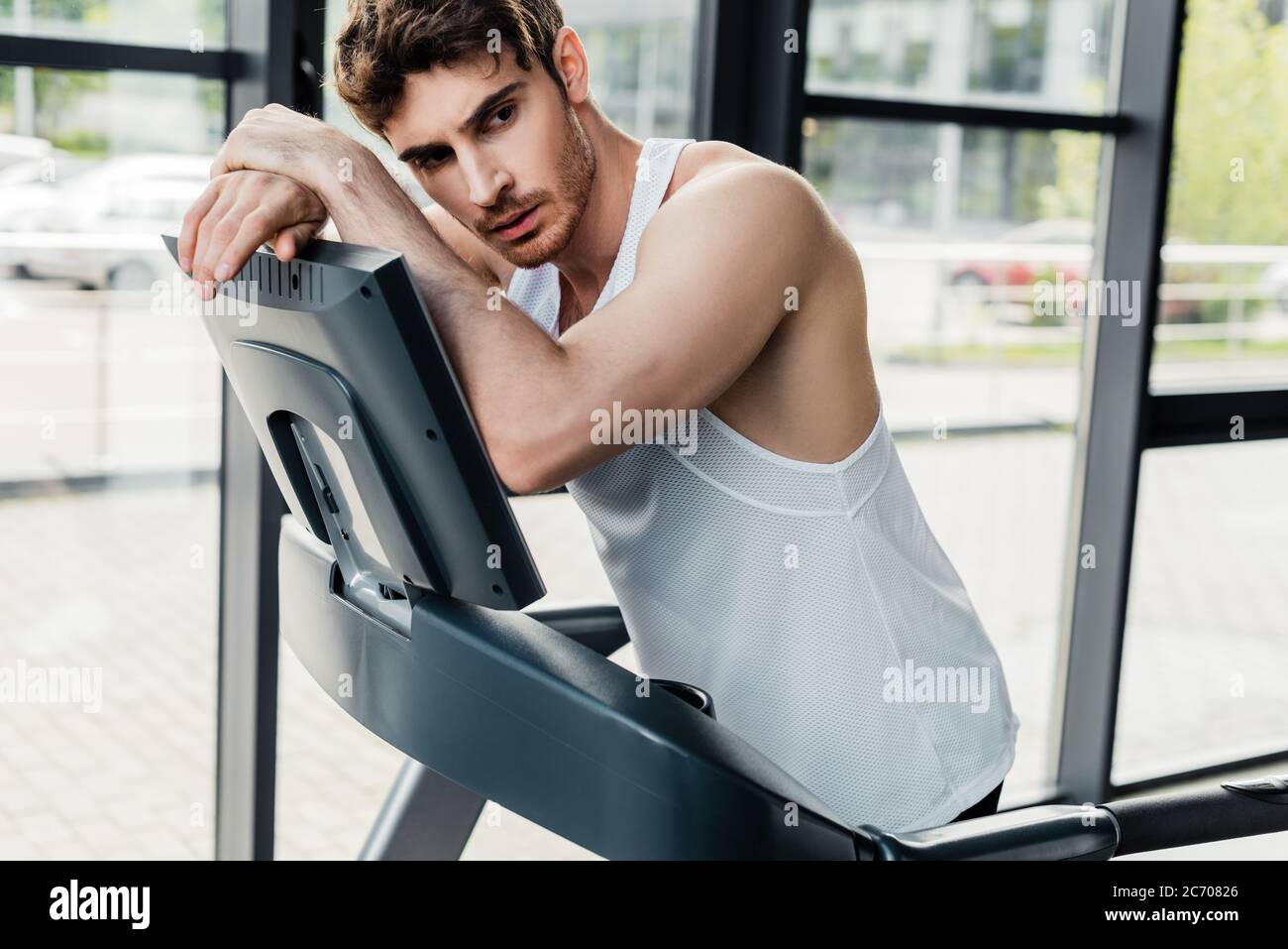 tired sportsman standing near treadmill in gym Stock Photo - Alamy