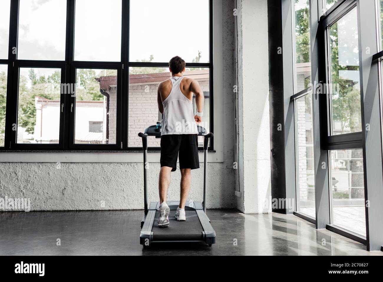 back view of man running on treadmill in gym Stock Photo - Alamy