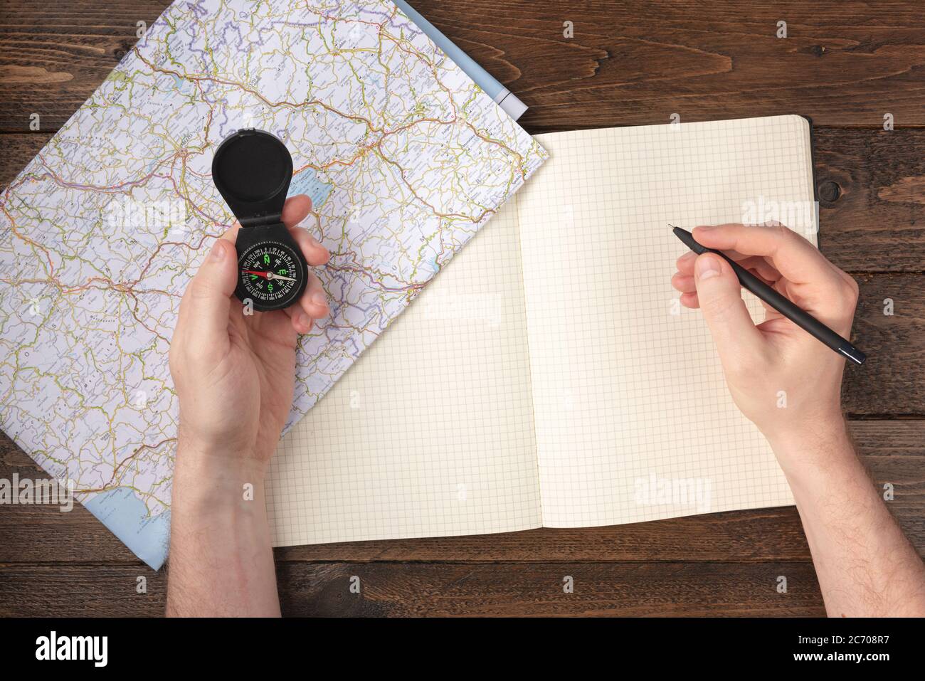 Travel planning concept. Hand writing in blank notepad with compass and ...