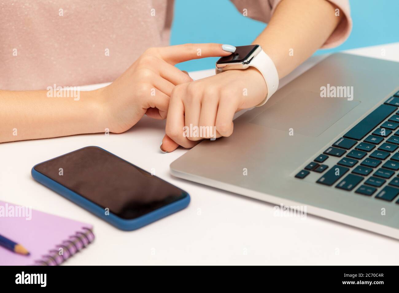 Closeup of woman employee looking at smart watch on her hand while ...