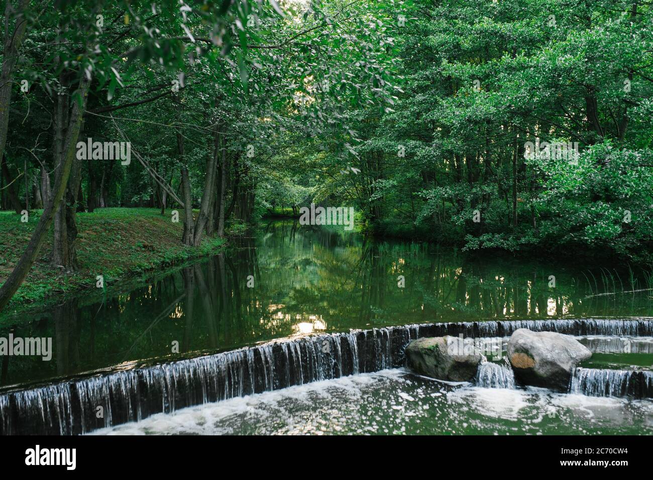 Beautiful cascading mini waterfall on the river in the forest Park ...