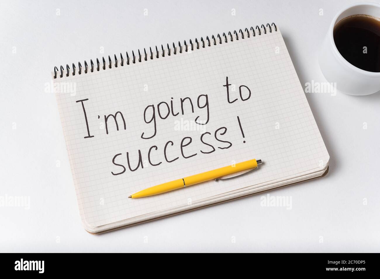 Im going to success notice. Notebook pen and cup of coffee on white ...