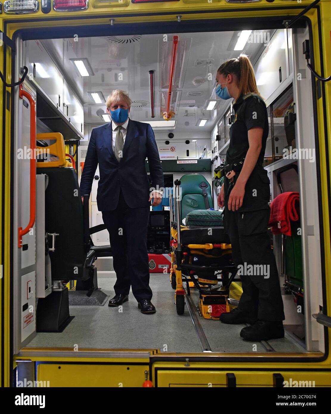 Prime Minister Boris Johnson, wearing a face mask, talks with a ...