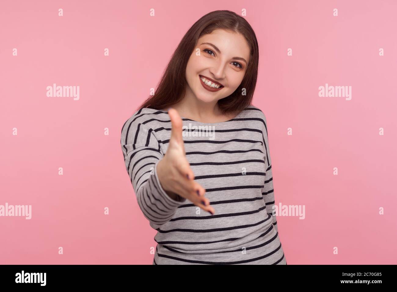 Welcome, nice to meet you! Portrait of happy amiable woman in striped ...