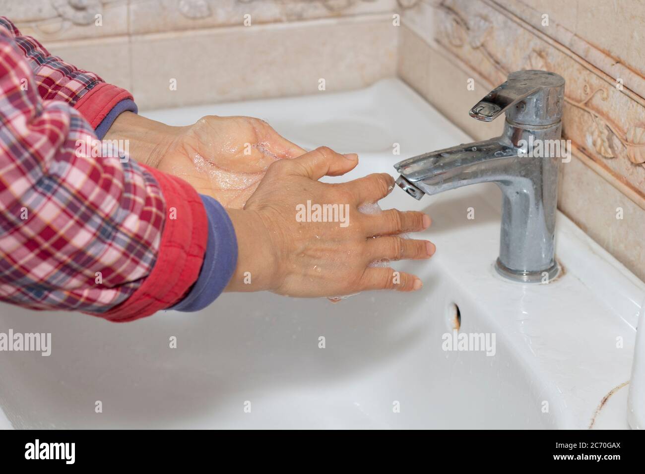 Washing hands under faucet hi-res stock photography and images - Alamy