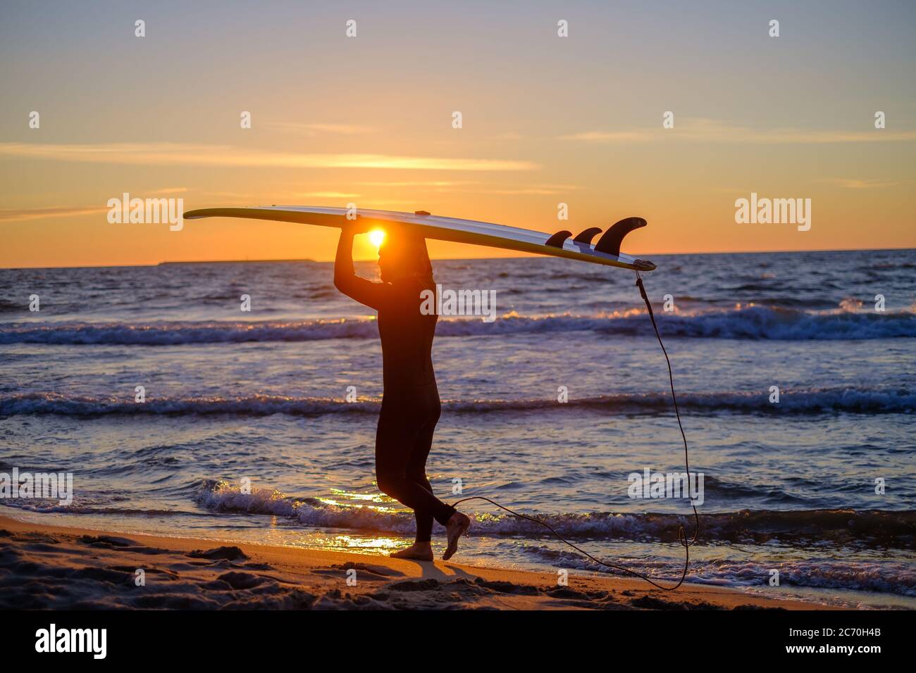 Surfer carrying surfboard near sea Stock Photo - Alamy