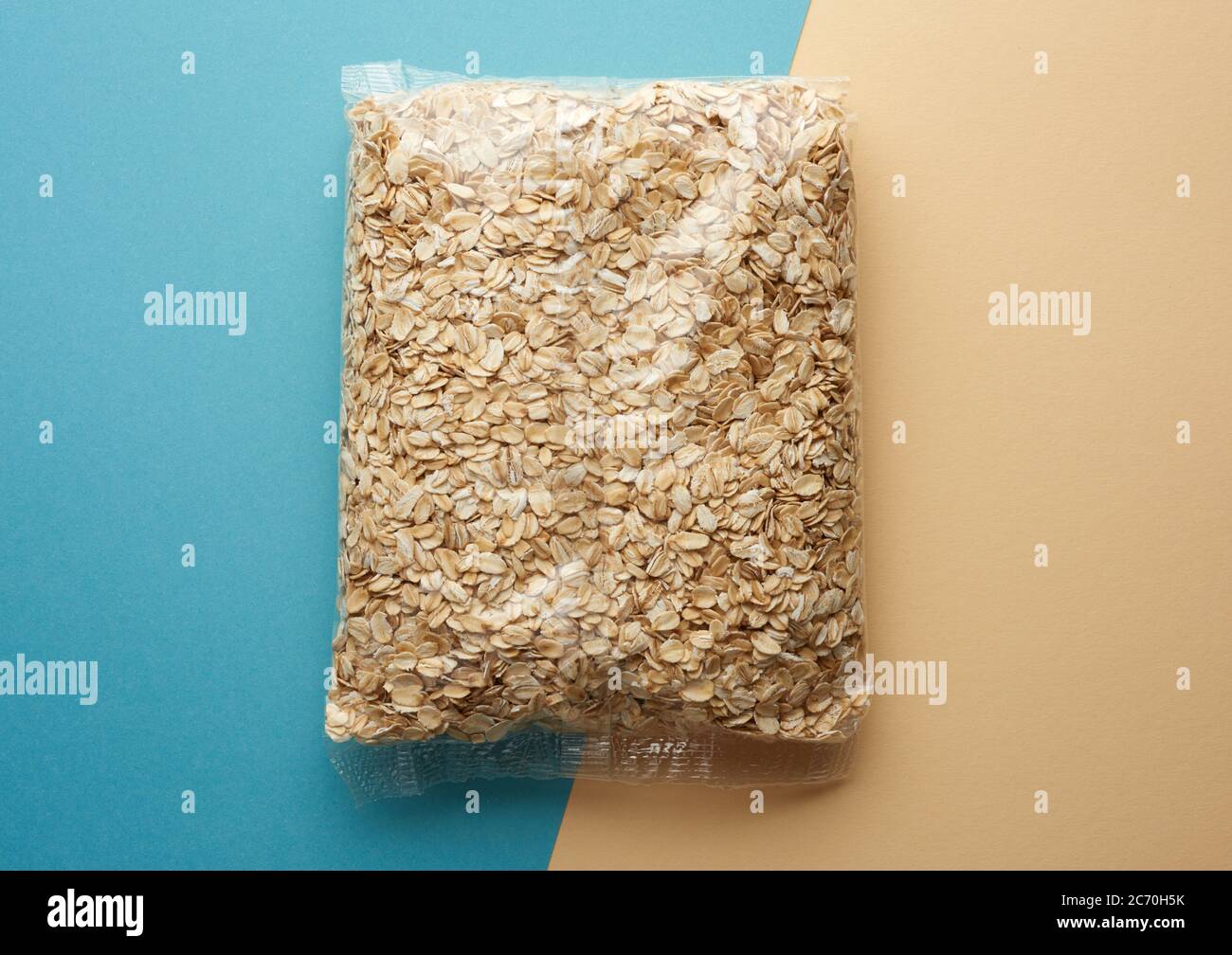 oatmeal in transparent plastic packaging on a blue-beige background ...