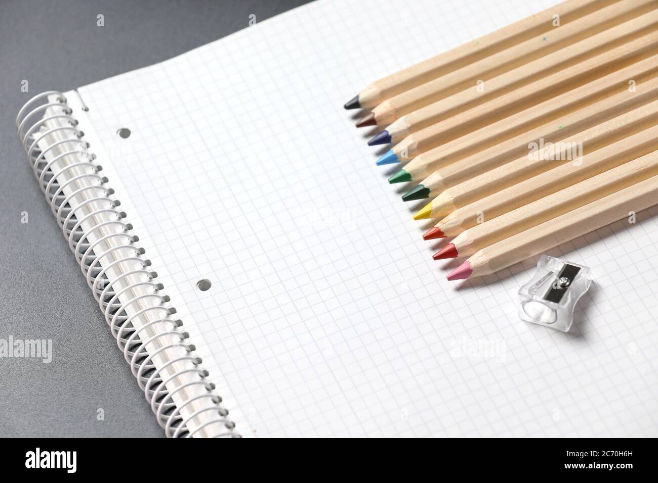 Flat lay view of white notebook , color pencils and pencil sharpener on ...