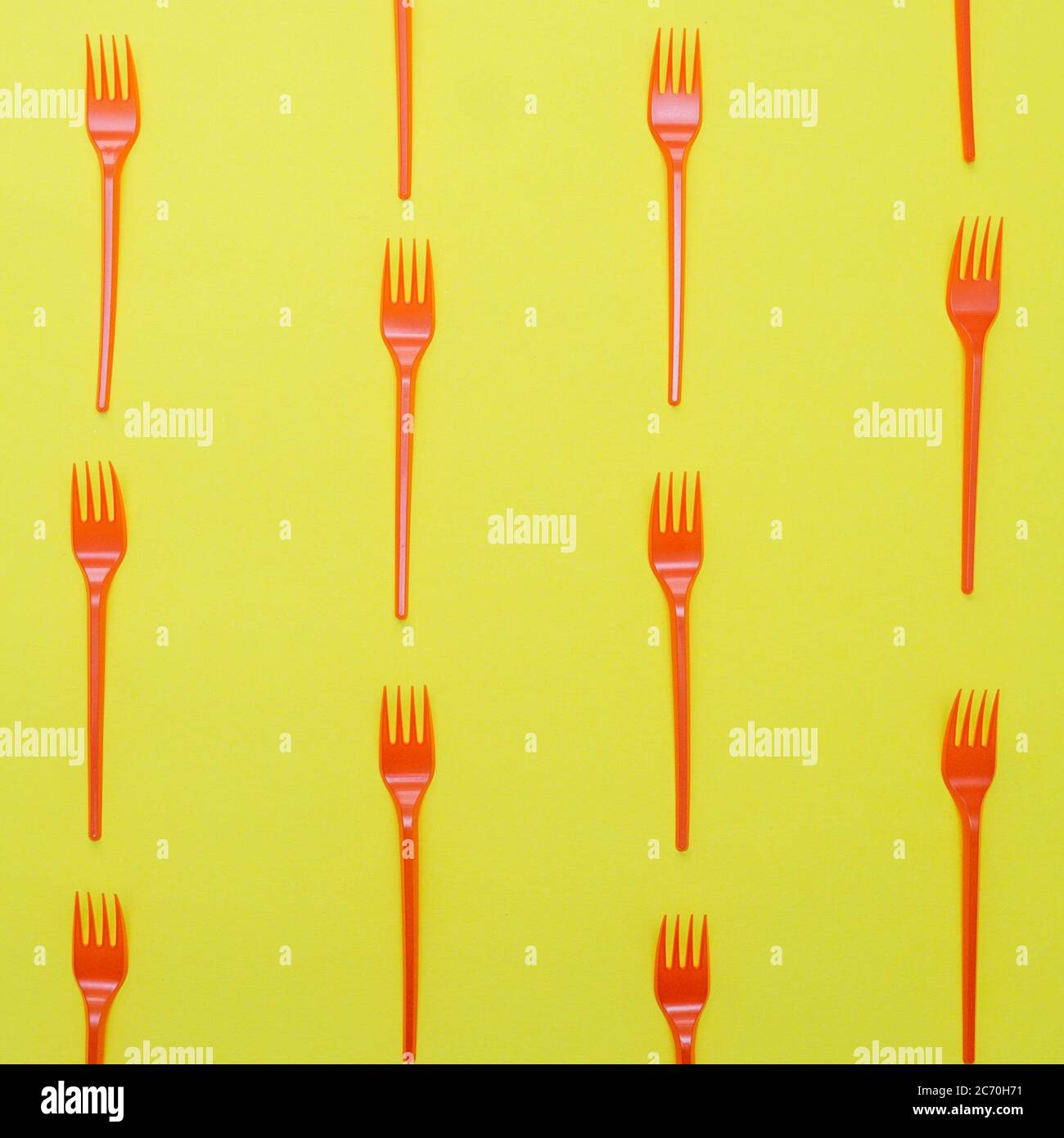 Plastic red forks on yellow background. Square Stock Photo - Alamy