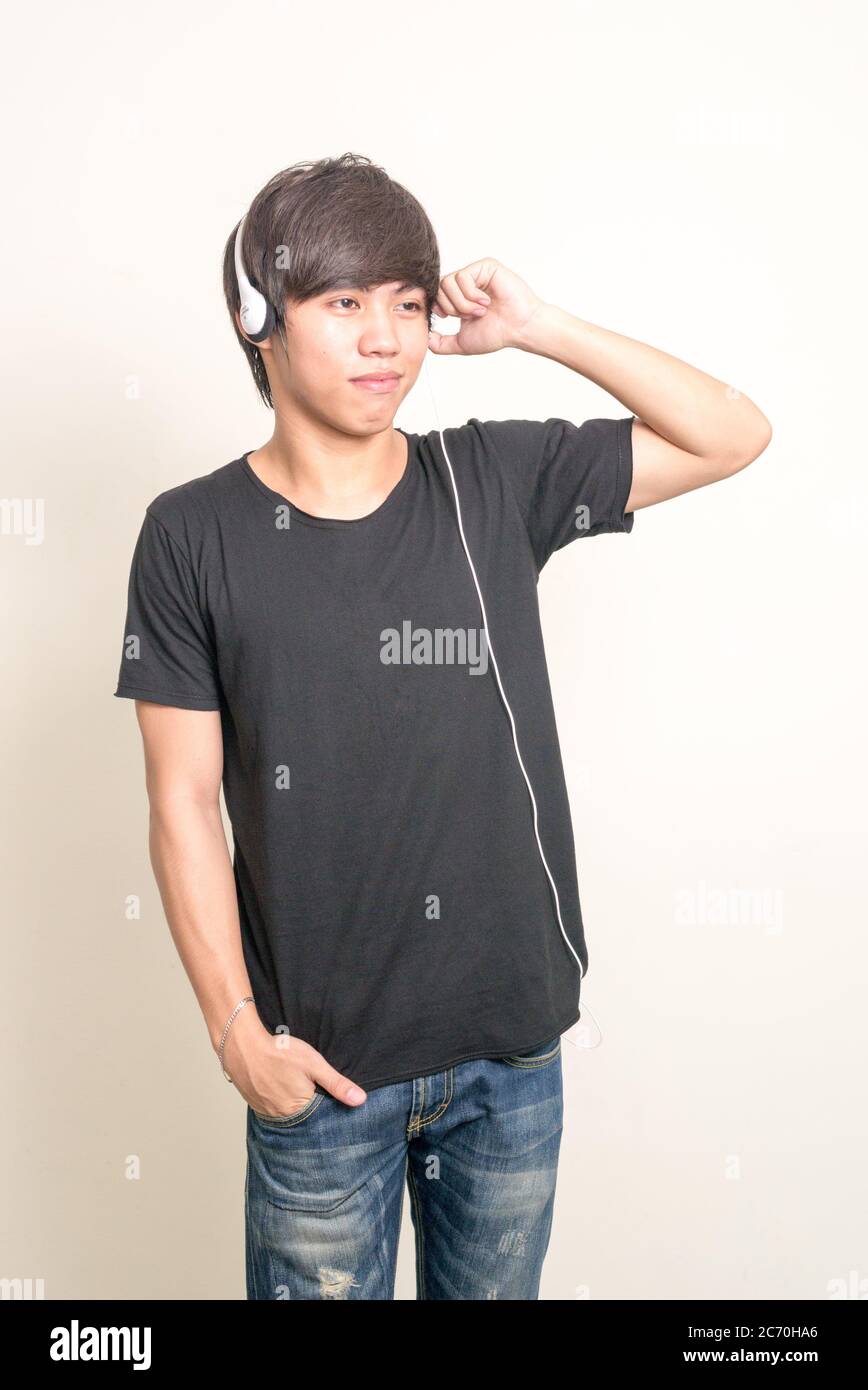 Portrait of young Filipino man thinking and listening to music Stock ...