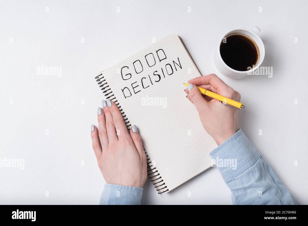 Top view of woman writes in notebook the inscription GOOD DECISION ...