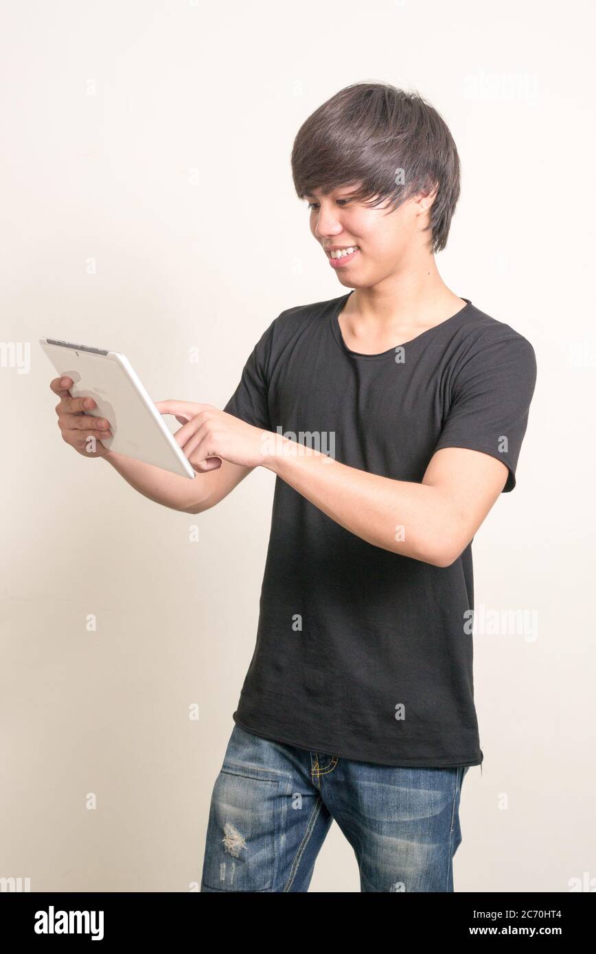 Portrait of happy young Filipino man using digital tablet Stock Photo ...
