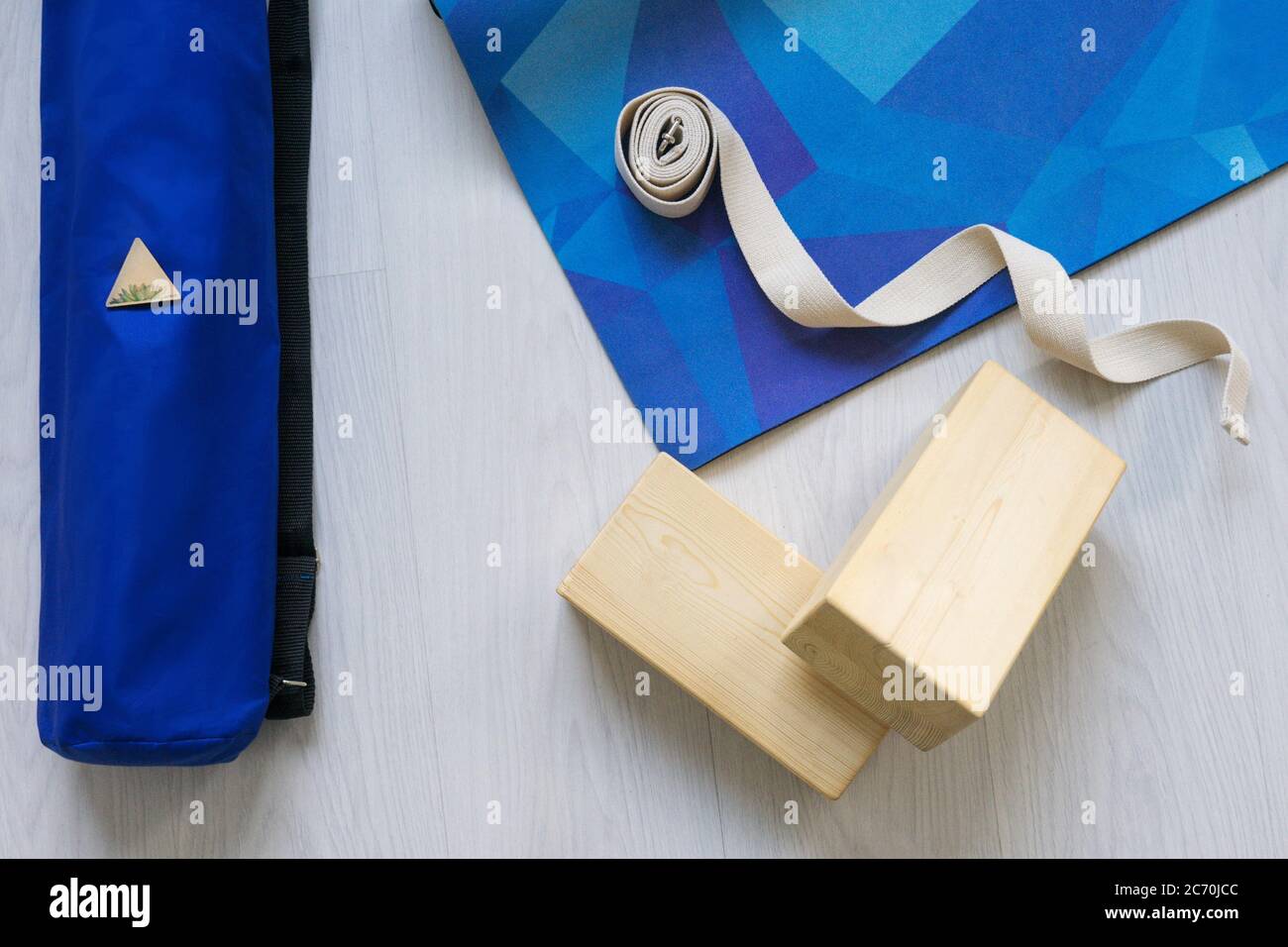 Flat lay from yoga equipment. Blue mat, blocks and belt on light ...