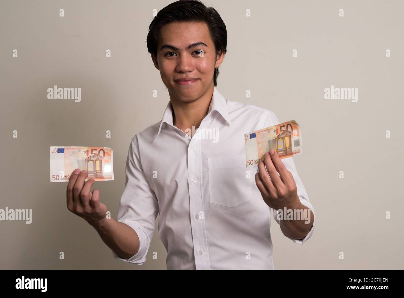 Portrait of young Filipino businessman holding money Stock Photo - Alamy