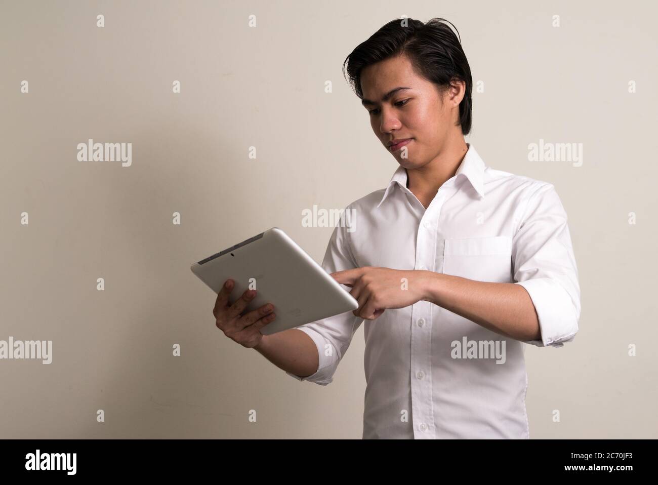 Portrait of young Filipino businessman using digital tablet Stock Photo ...