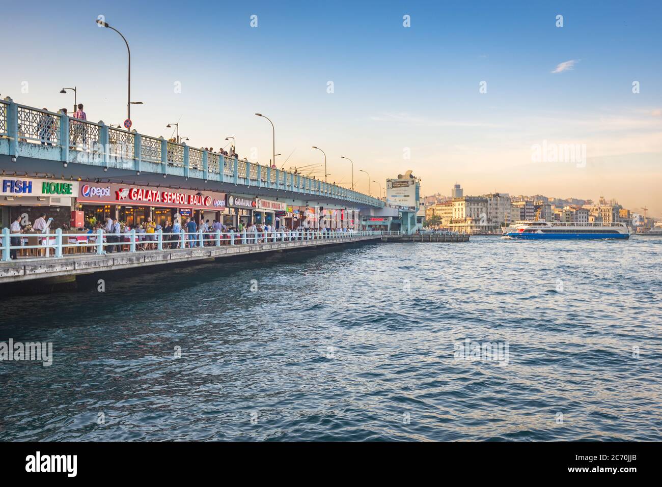 People dining, walking, and fishing along the Galata Bridge in Istanbul ...