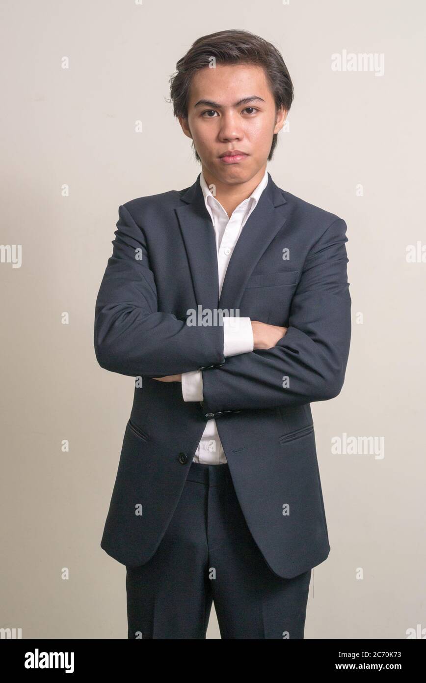 Portrait of young Filipino businessman in suit with arms crossed Stock ...