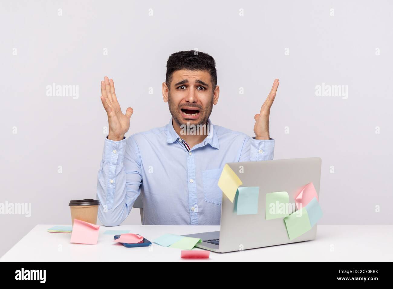 Overtime, overwork concept. Shocked scared man employee sitting in ...