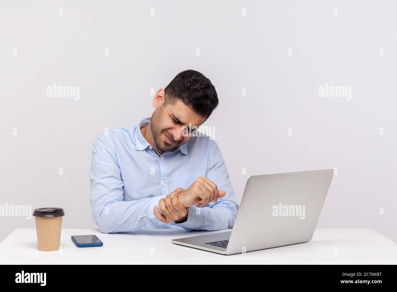 Male employee sitting office workplace with laptop, massaging sore ...