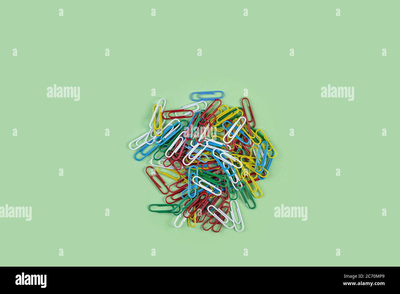 Bunch of colorful paper clips on green background. Creative flat lay ...