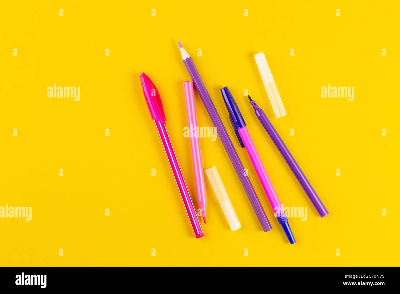 Set of colored pens on yellow paper background with copy space. Flat ...