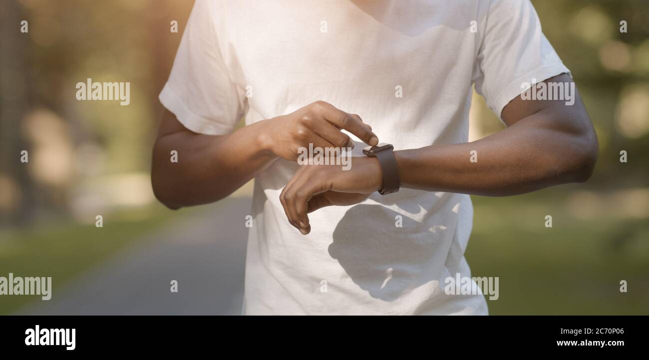 African american runner checking time on his smartwatch Stock Photo - Alamy