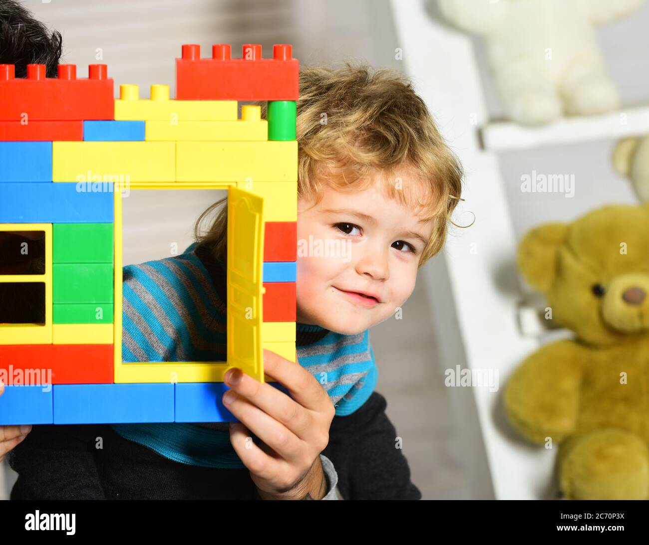 Boy plays with toys on nursery room background. Childhood and active ...