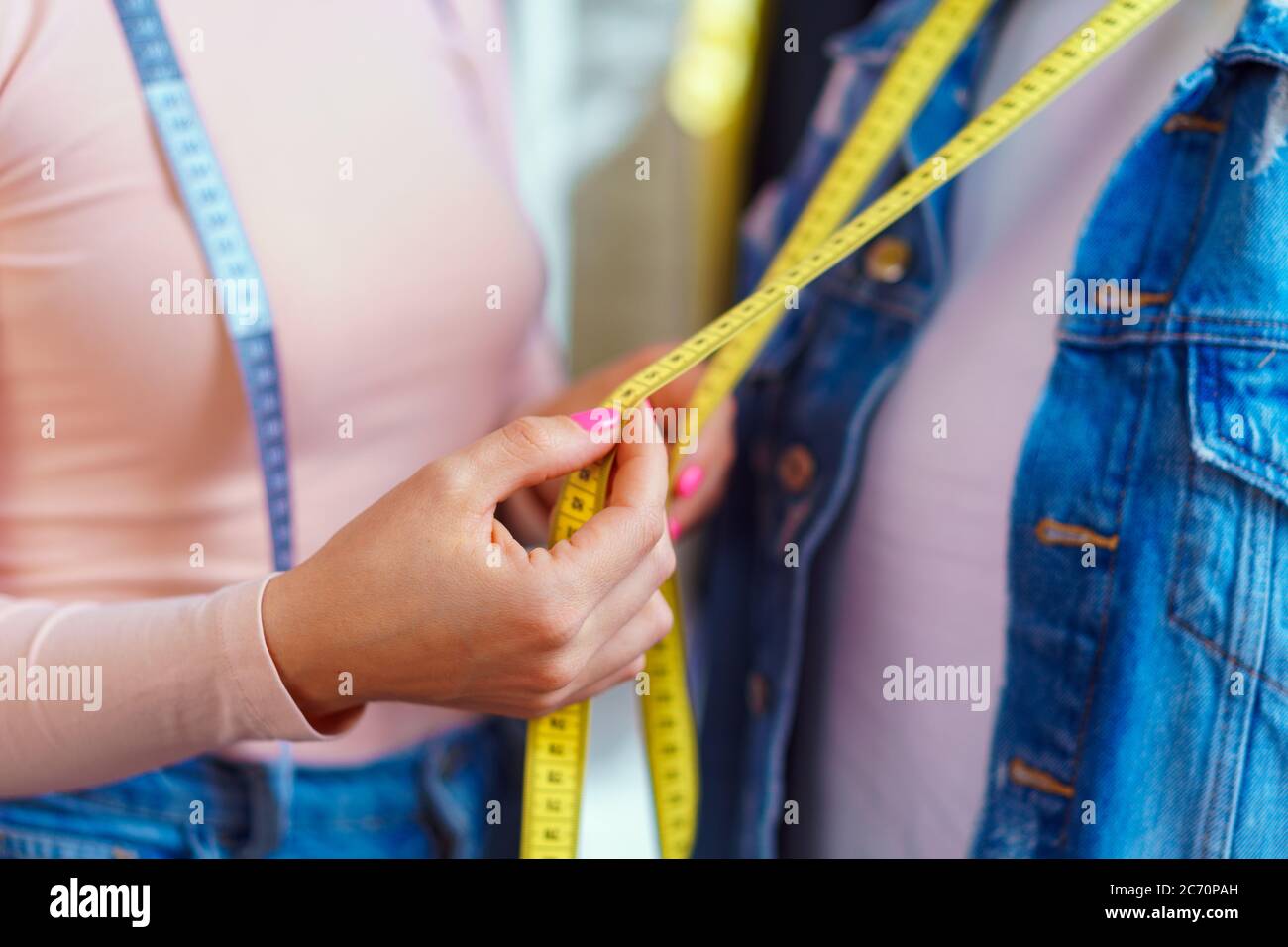 Young woman seamstress making measurements with mannequin Stock Photo ...