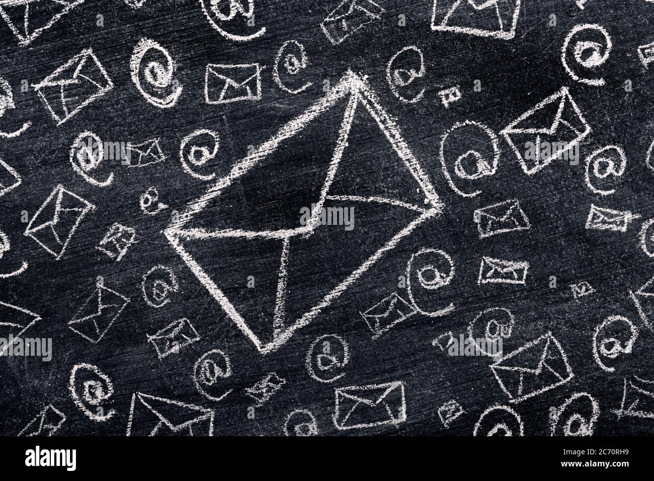 E-mail concept with envelopes and at symbols drawn in chalk on ...