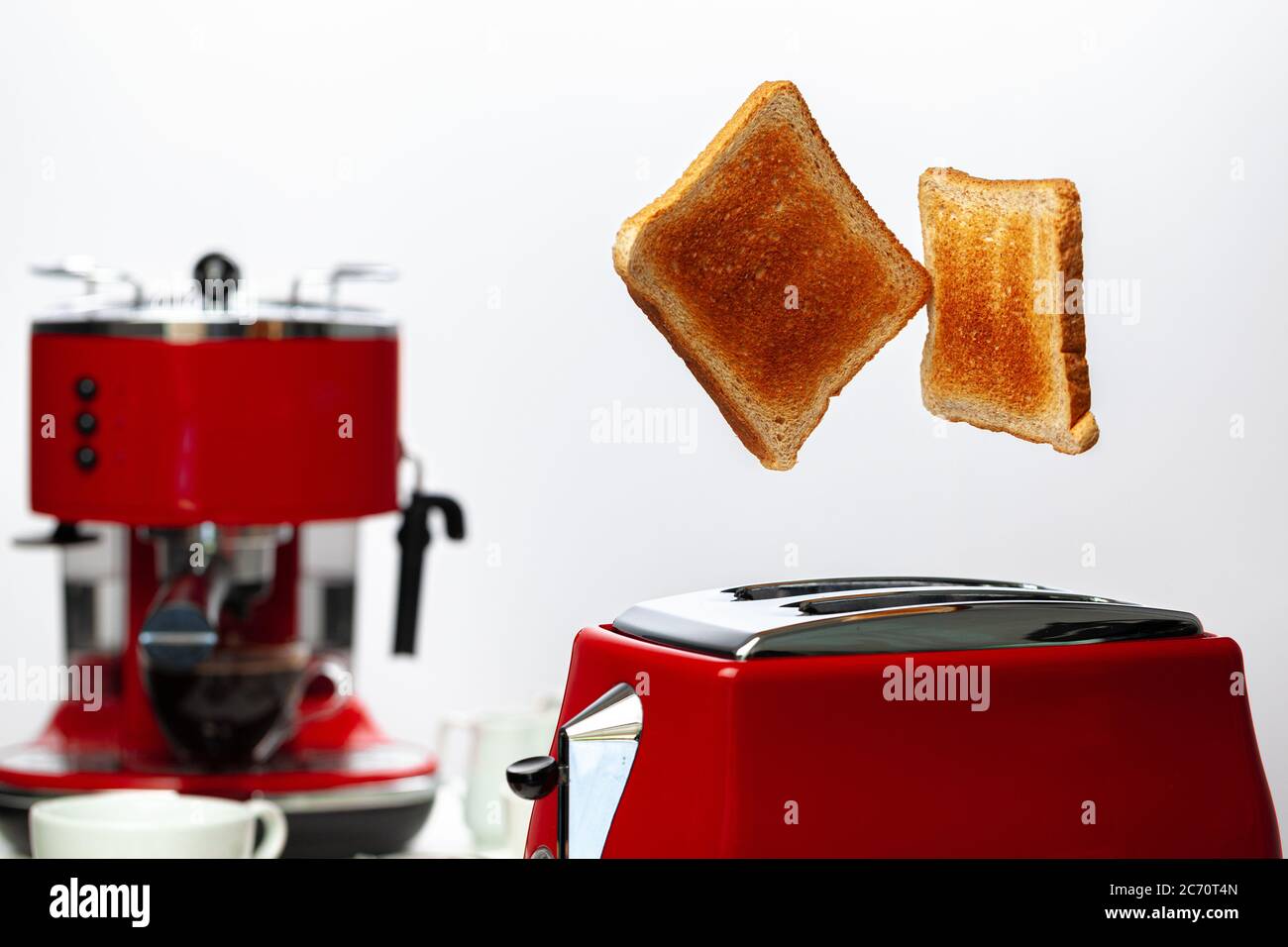 Two toasts jumping out of red toaster against white background Stock ...