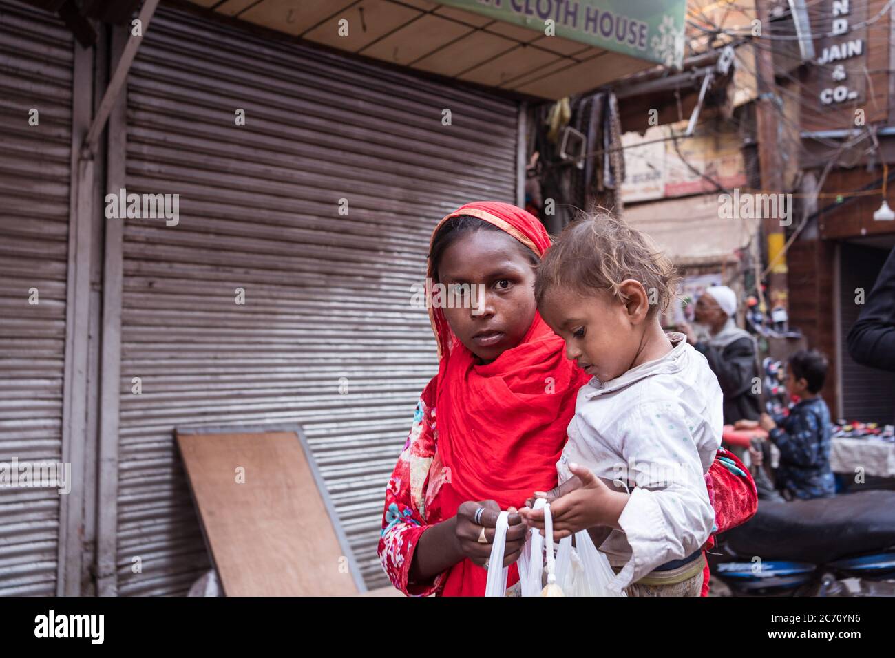 New Delhi / India - February 18, 2020: poor little girl holding little ...