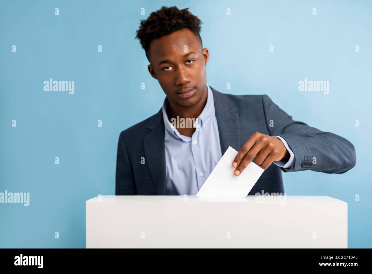 Concentrated african american businessman pulling paper in vote ballot ...