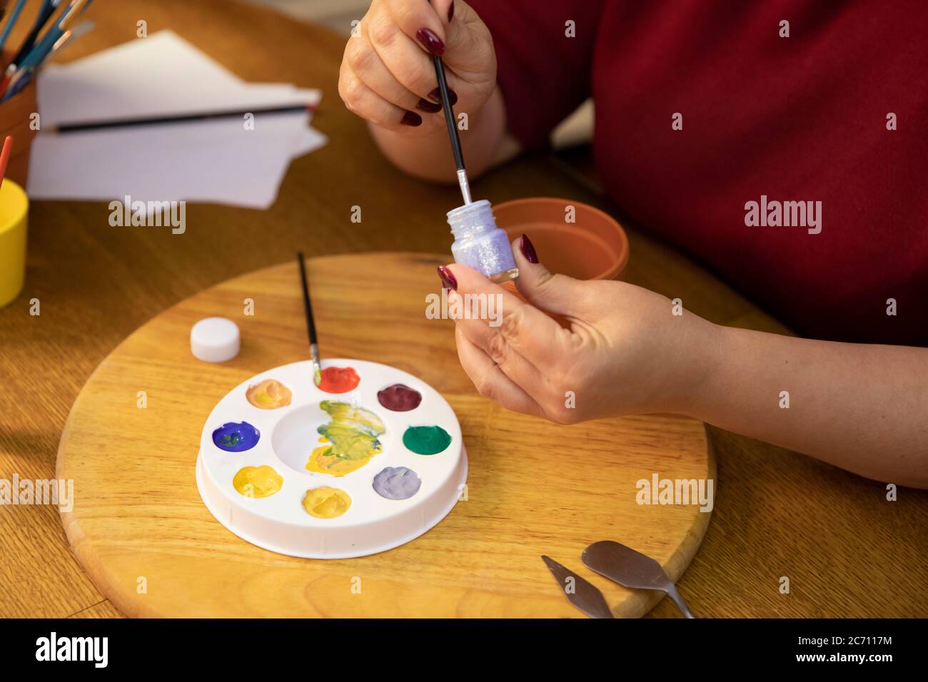 Close up female artist's hands mixes colors on paint palette, art ...