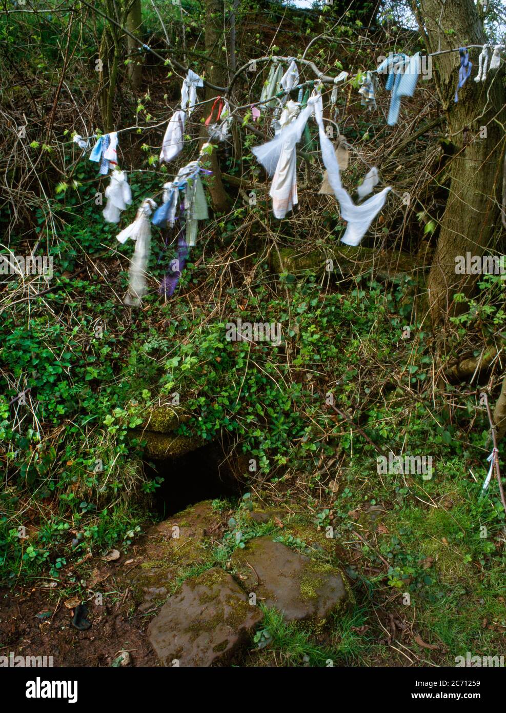 A holy well decorated with clouties on the hillside below the E end of ...