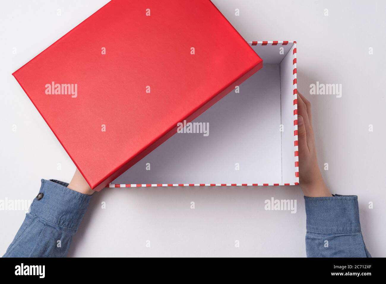 Open Empty red box in children's hands on white background. Top view ...
