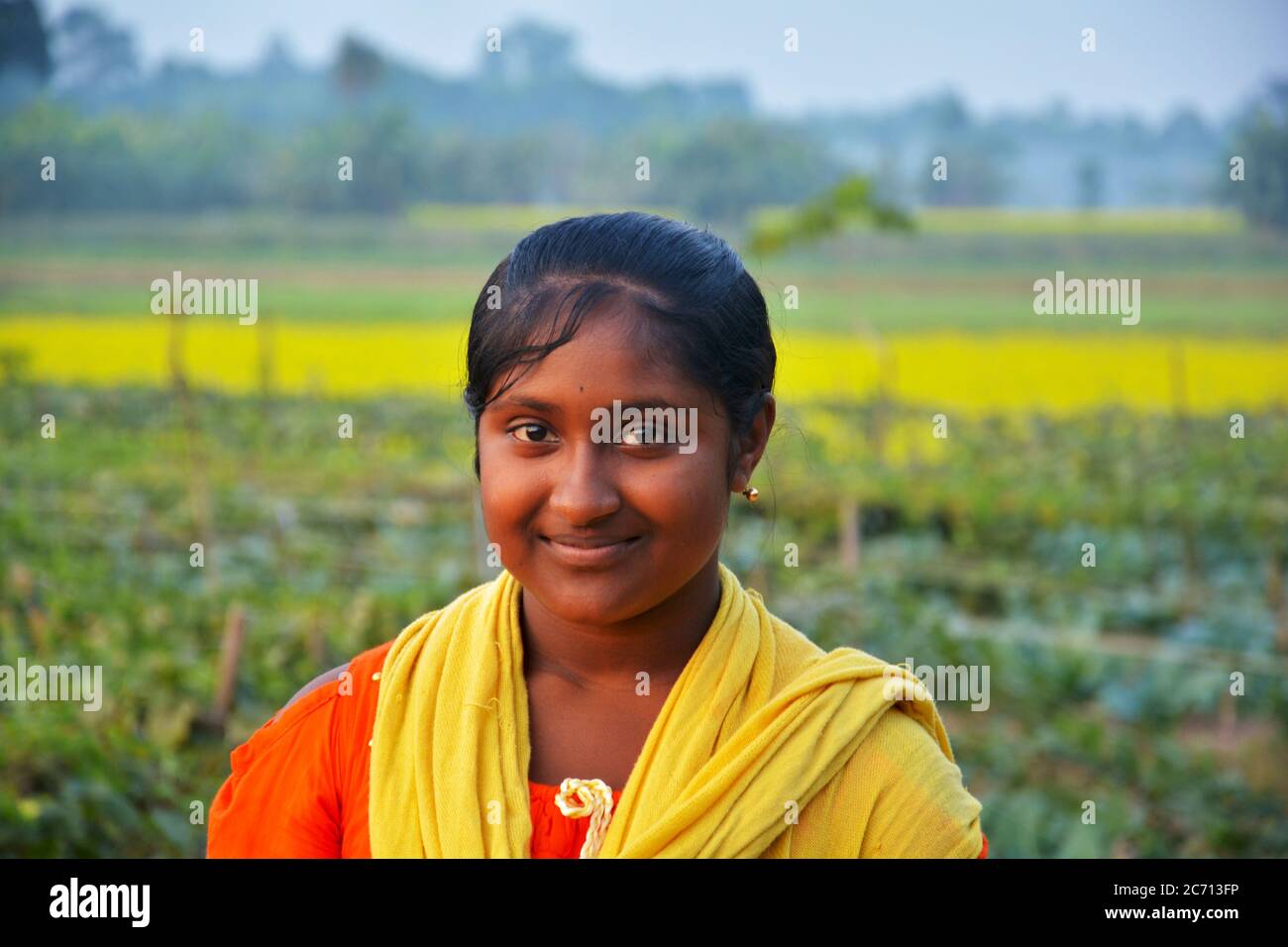 An Indian teenager girl smiling in a rural village field, selective ...