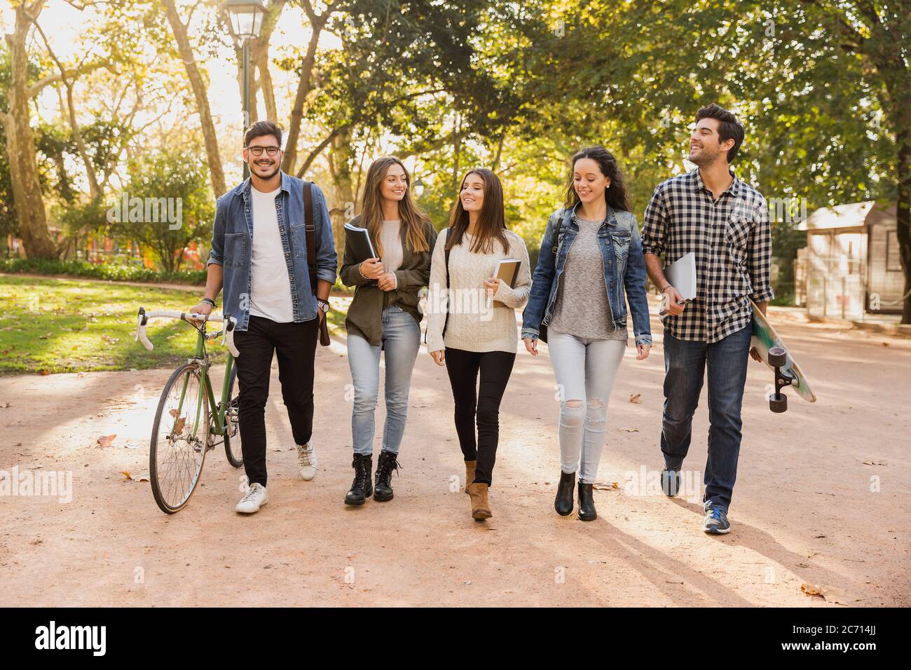 Group of students walking together in the park Stock Photo - Alamy