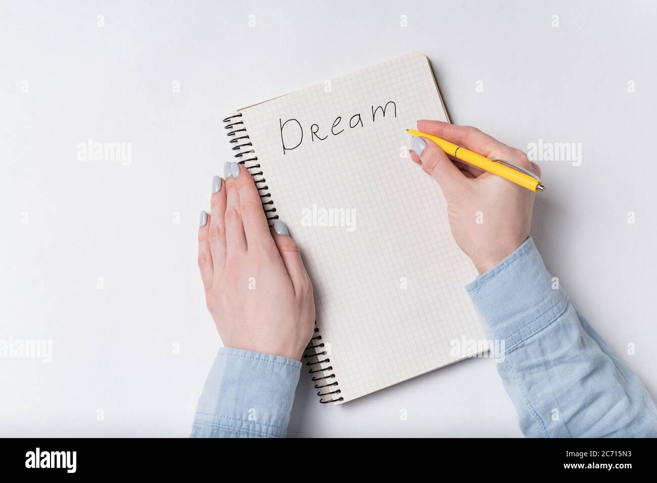 Female hand writing in notebook DREAM. Text on copybook Stock Photo - Alamy