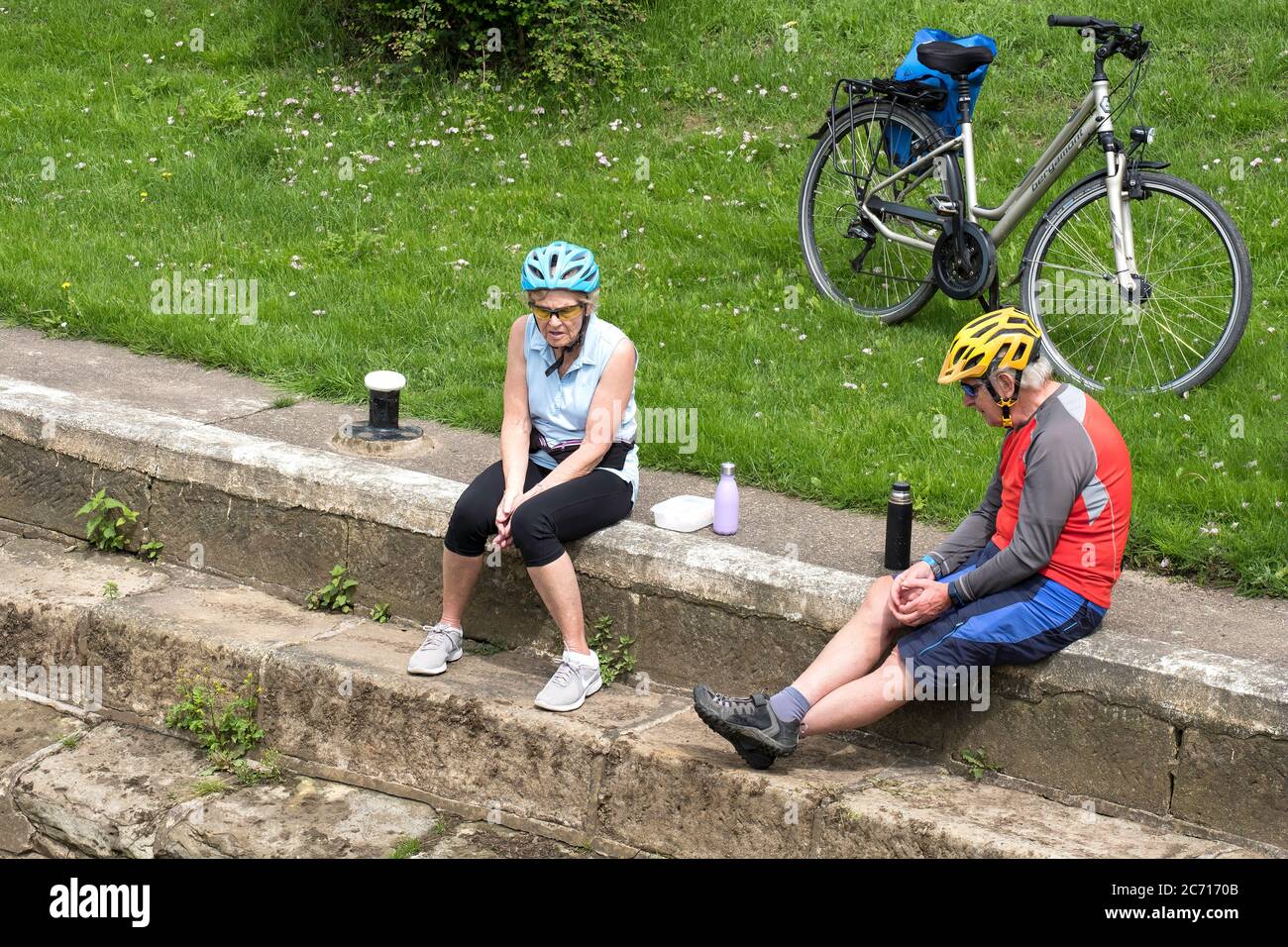 Two elderly cyclists sitting down outside Stock Photo - Alamy