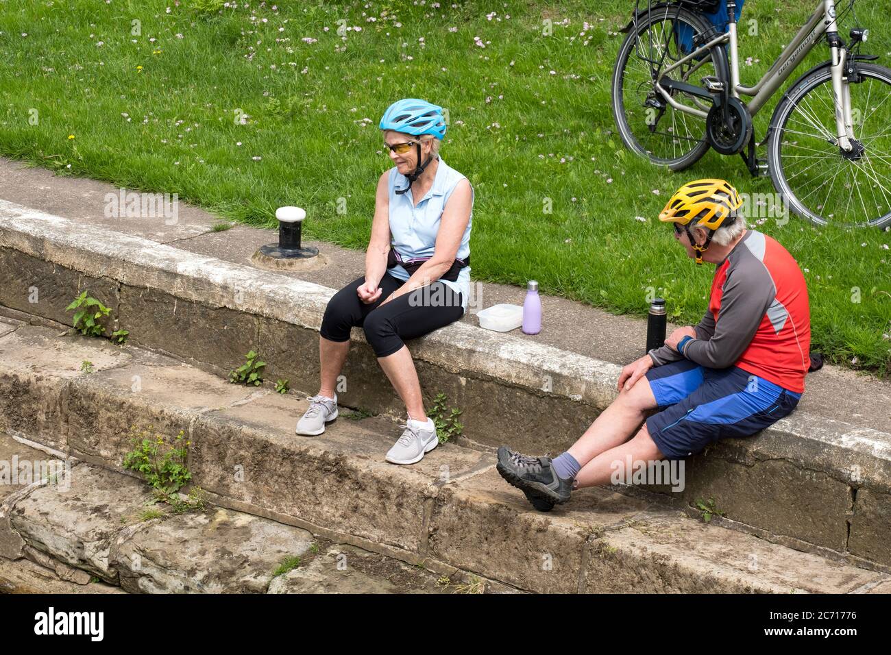 Two elderly cyclists sitting down outside Stock Photo - Alamy