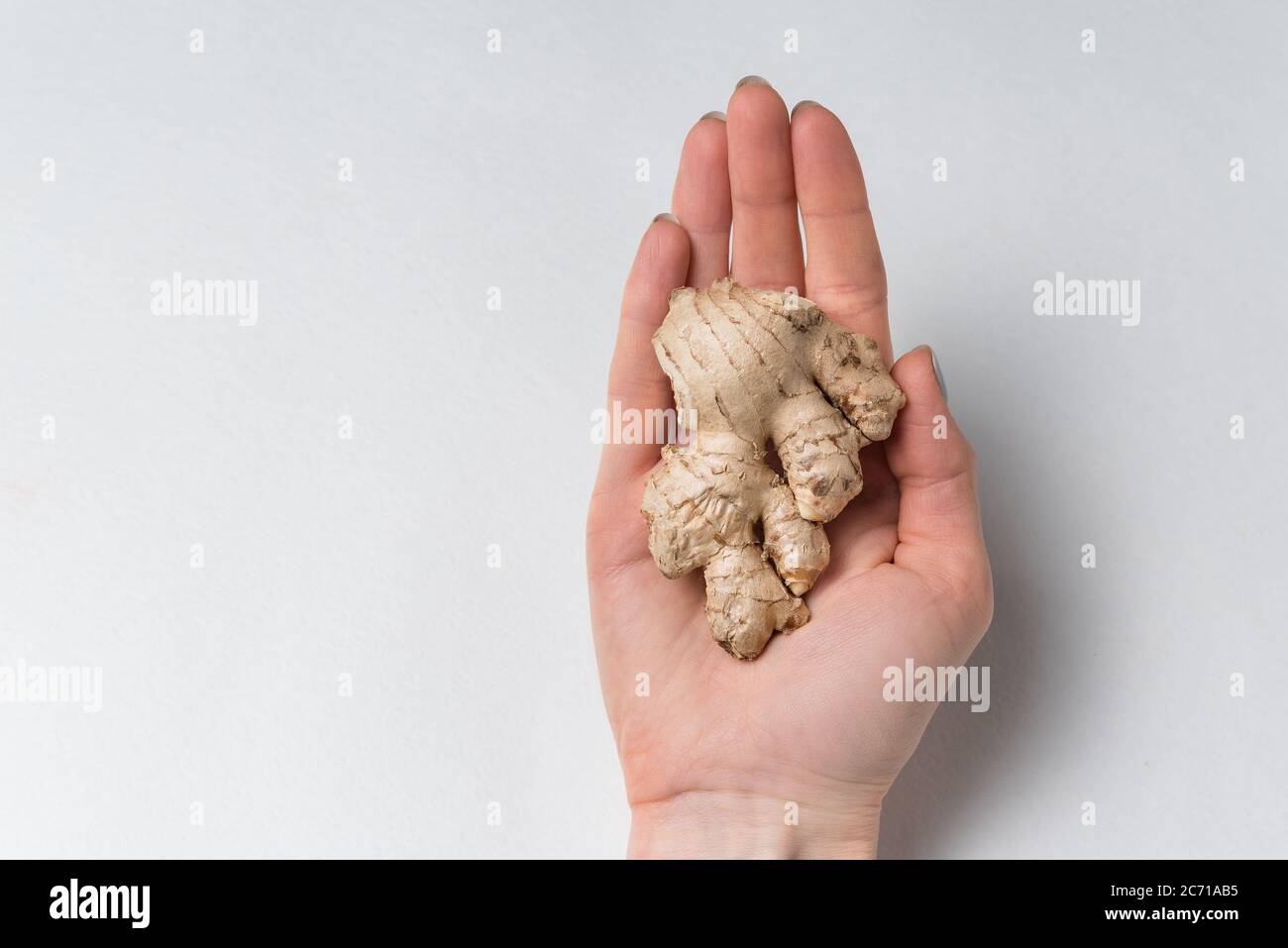 Ginger root lies in female hands on white background. Products for ...