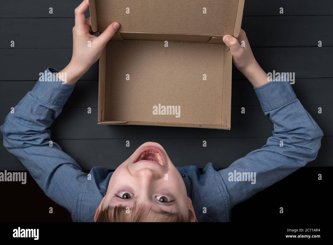 Funny boy with an open empty box. Top view Stock Photo - Alamy