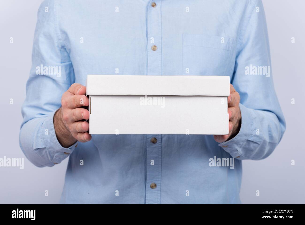 Male hands holding a cardboard box. Front view. Express delivery ...