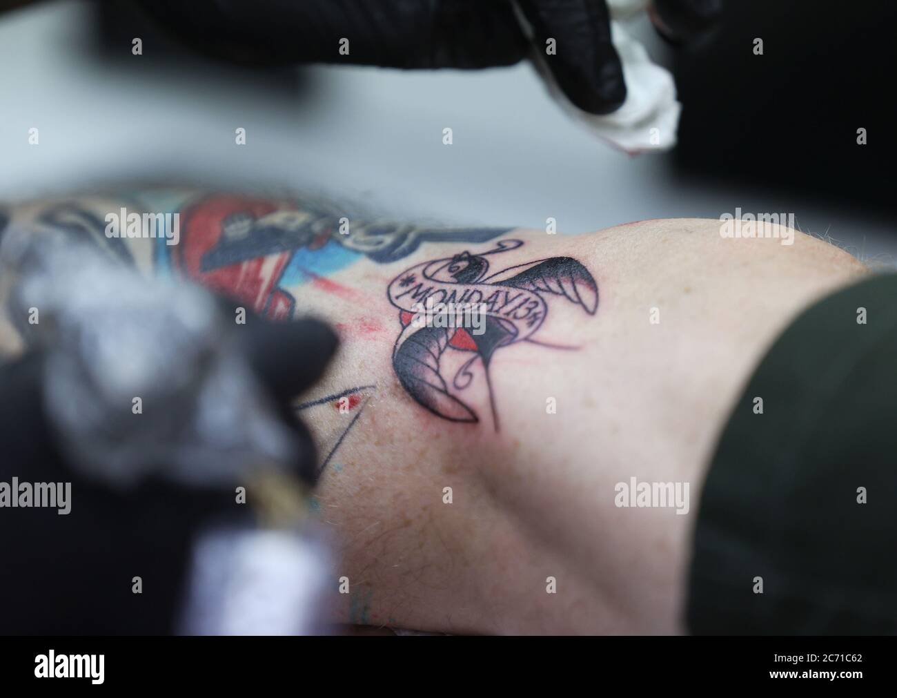 Tattoo artist Naresh Bhana gives customer Sean Murphy a traditional ...