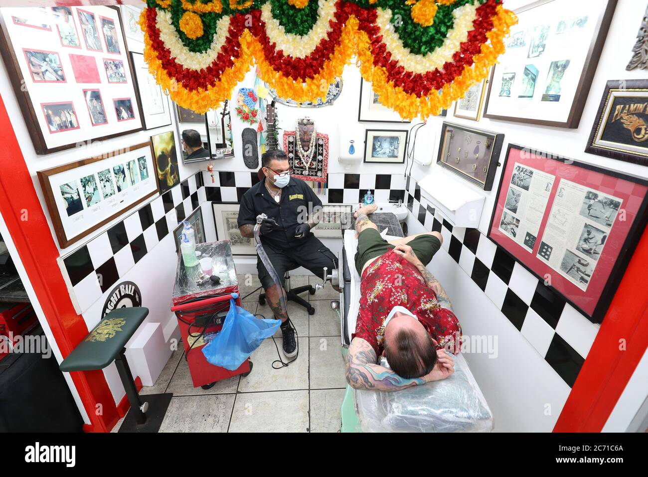 Tattoo artist Naresh Bhana gives customer Sean Murphy a traditional ...
