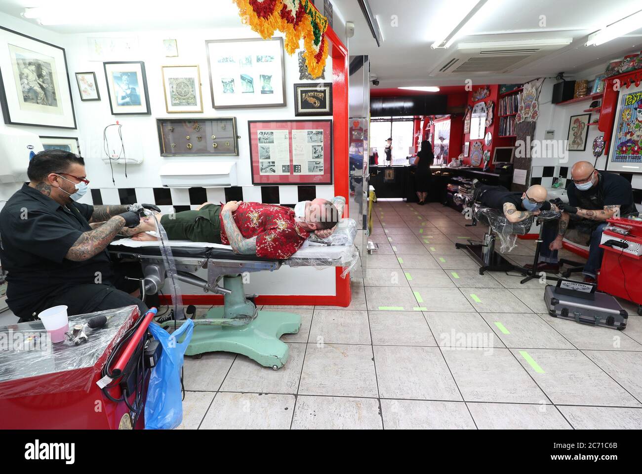 Tattoo artist Naresh Bhana (left) gives customer Sean Murphy a ...