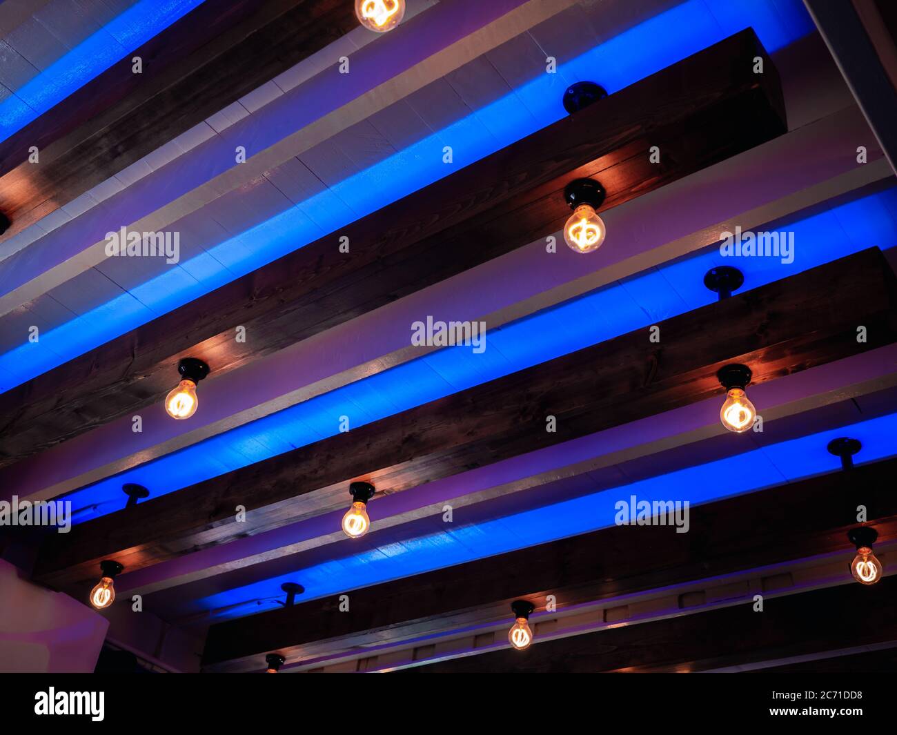 Hard and bold wood ceiling decoration with vintage light bulbs. Glowing ...