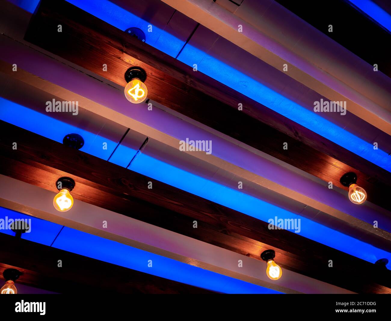 Hard and bold wood ceiling decoration with vintage light bulbs. Glowing ...