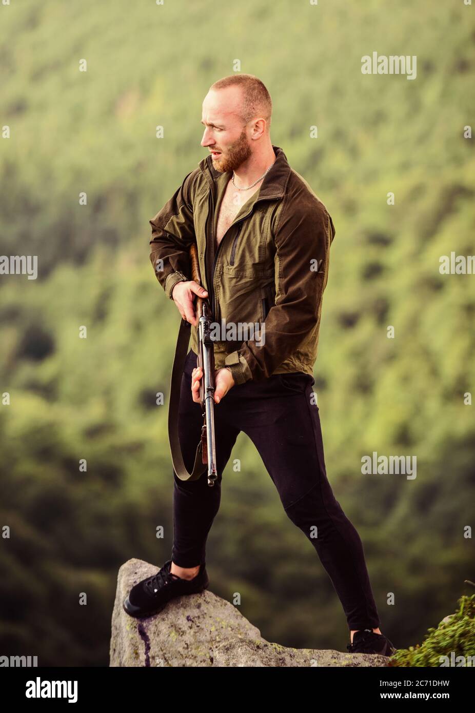 Illegal hunting. Poaching concept. Poacher stand on edge of cliff ...