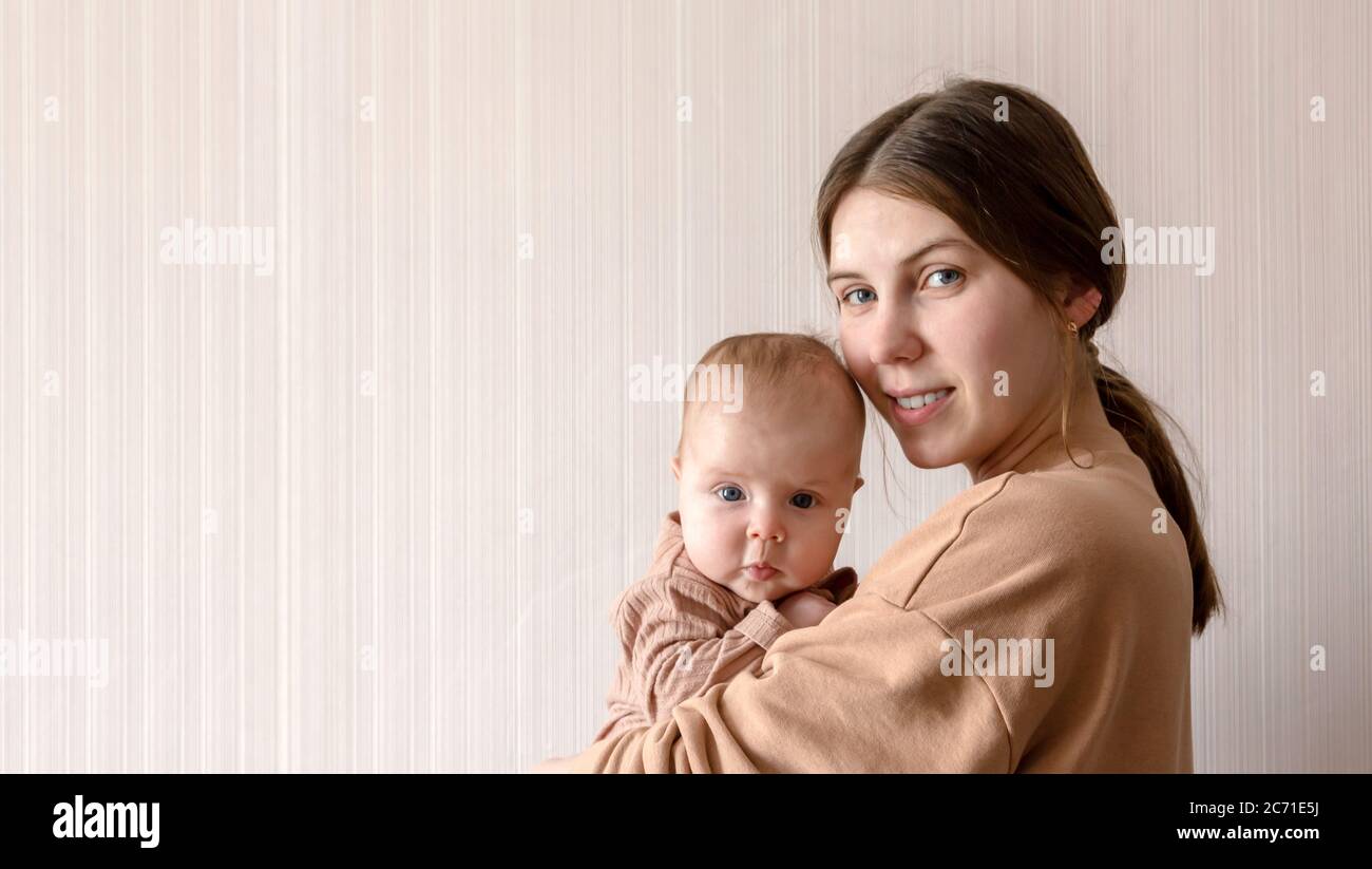 A young mother holds a child girl who is 3 months old. The brooding ...